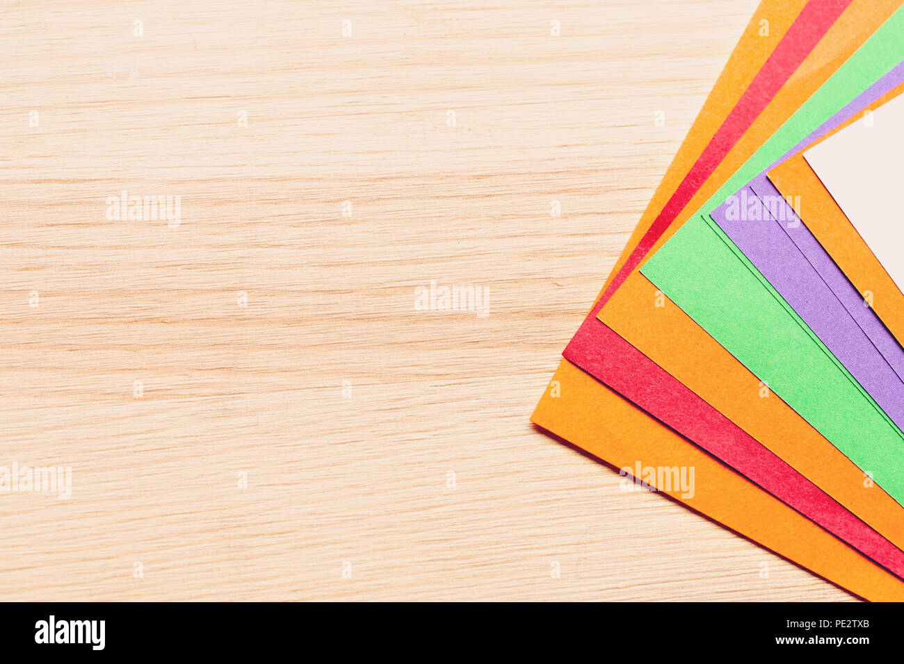 Color paper for origami lies on a fan of a light wooden table Stock ...