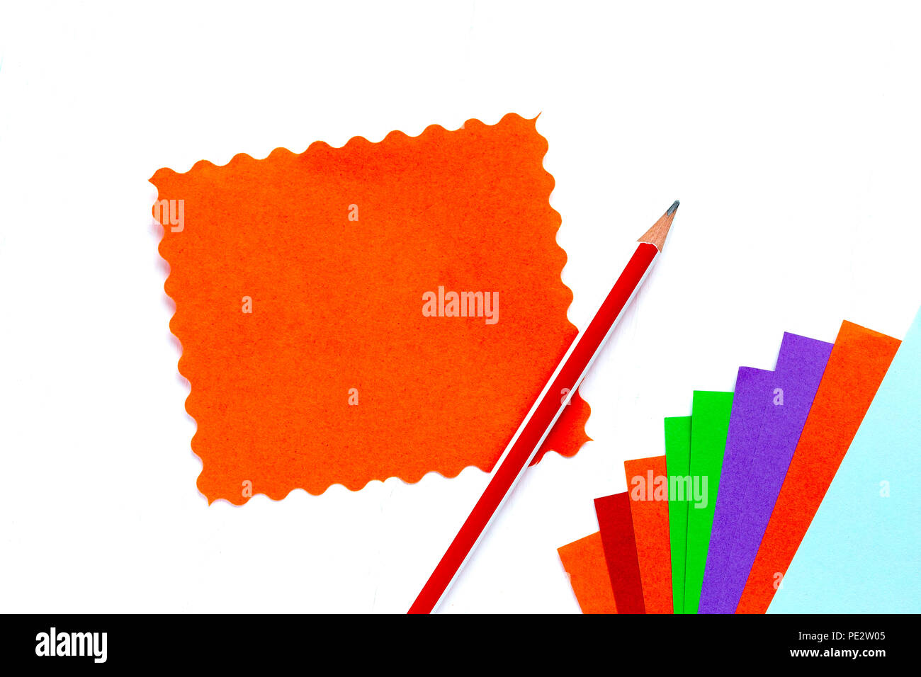 Color paper for origami lies with a fan, an orange sheet of paper with ...