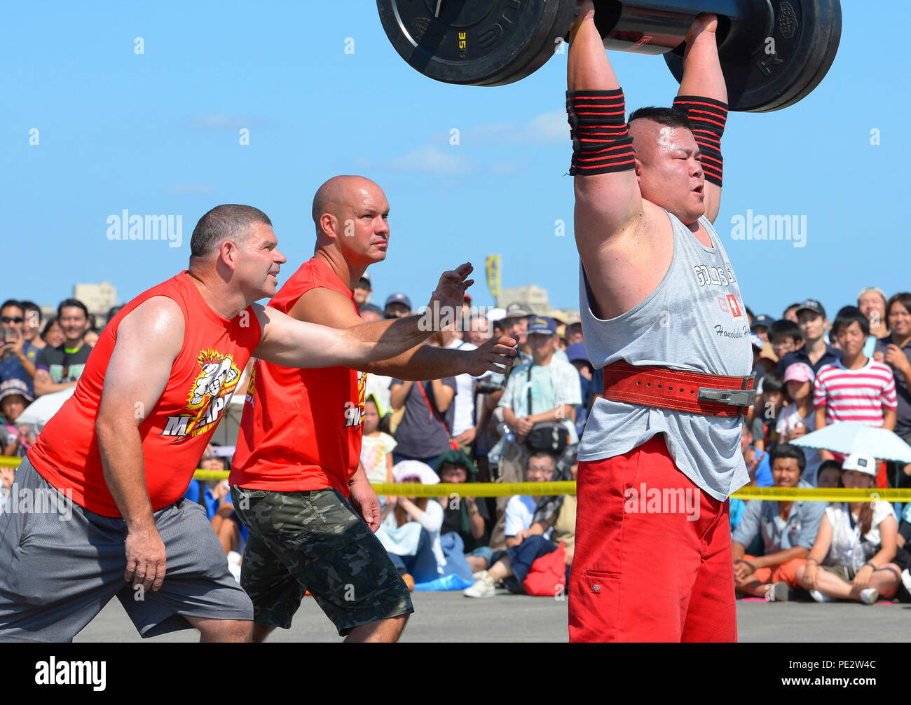 A contestant in the Strong Man Competition lifts weight over his head ...