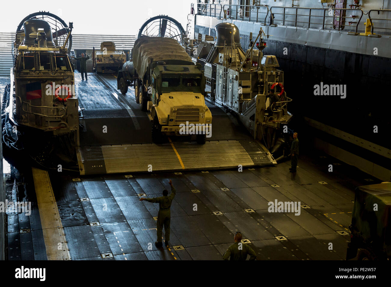 Marines and Sailors load vehicles onto a Landing Craft Air Cushion ...