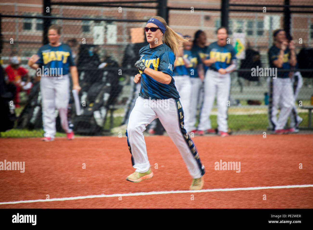 A member of the U.S. Navy women’s softball team runs to home plate ...