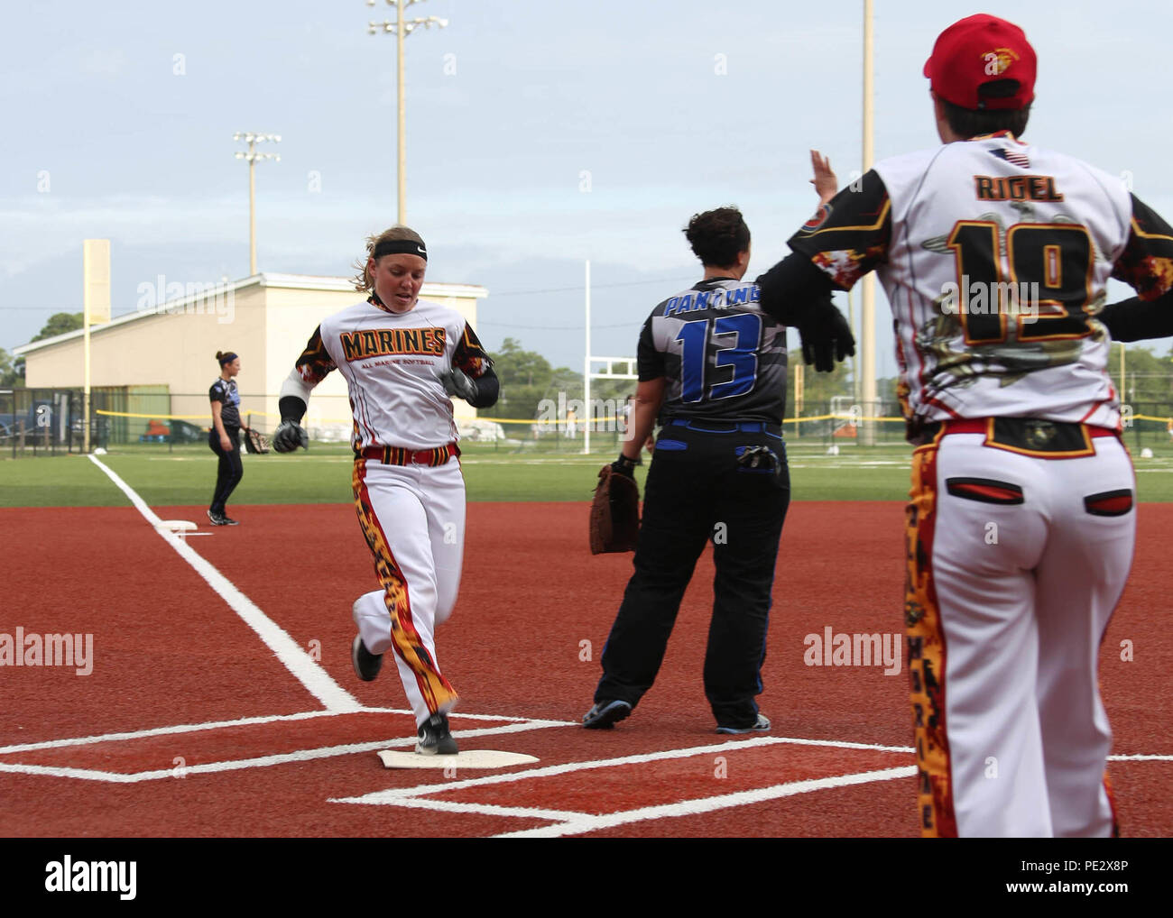 A member of the U.S. Marine Corps women’s softball team scores a run ...