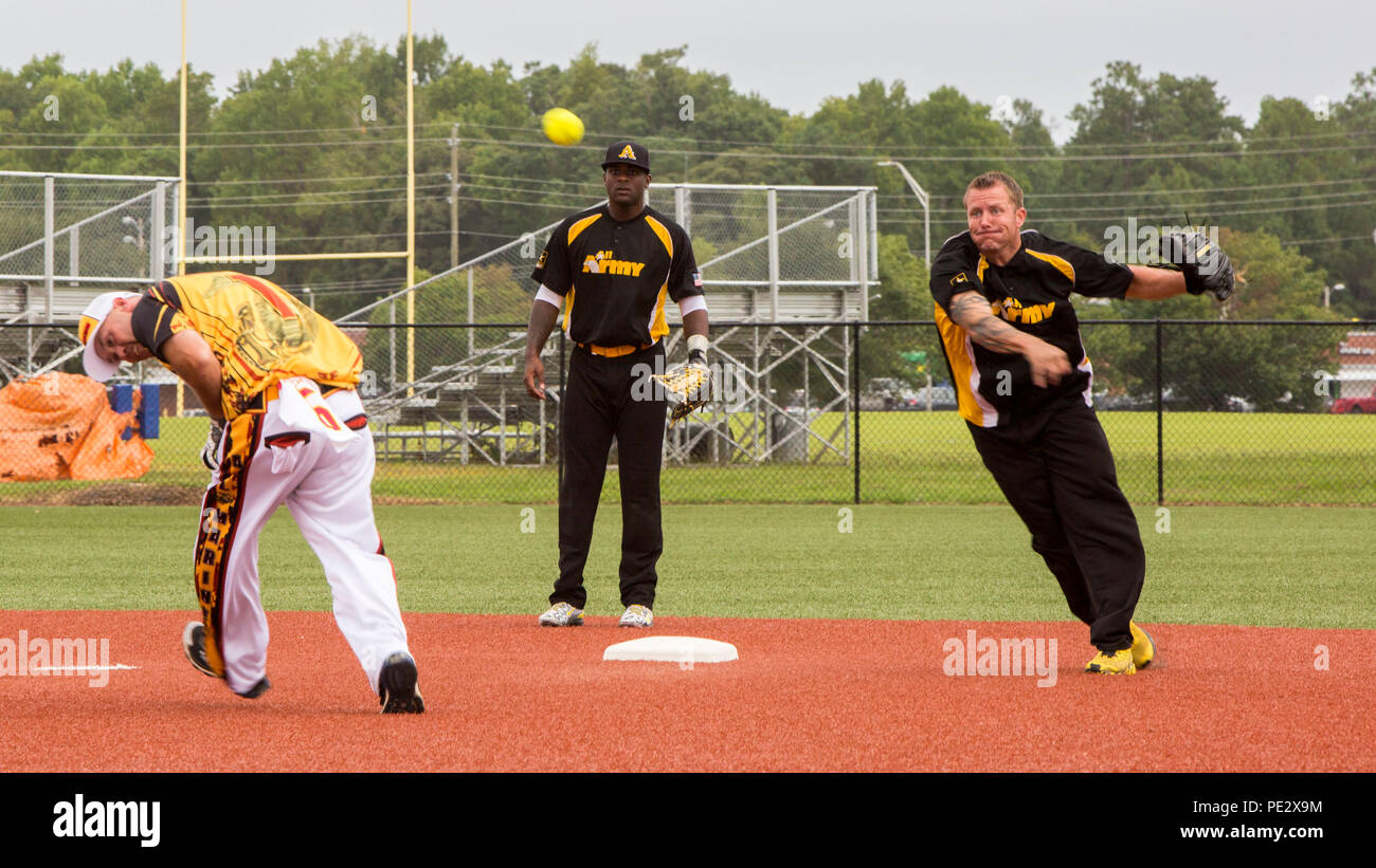 A member of the U.S. Army men's softball team throws to third base ...