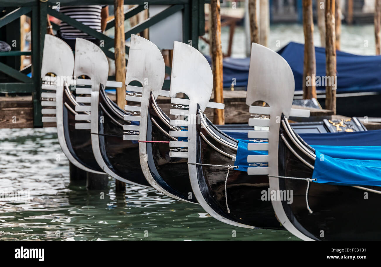 Traditional venetian gondolas lined up in a picturesque canal in Venice ...
