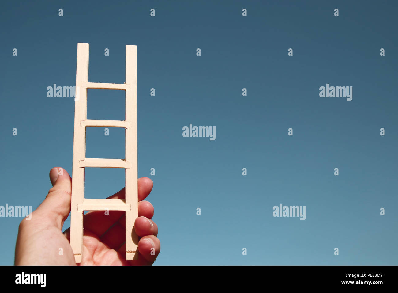 image of man hand holding a ladder against the sky. education and ...