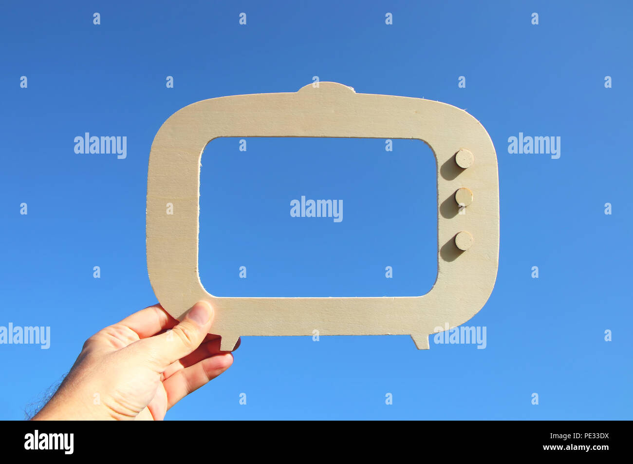 image of hand holding tv frame in front of sky. capture the moment or ...