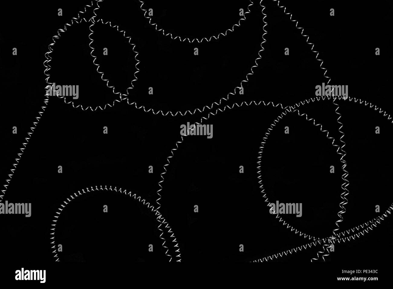 Round shapes of stretched metal springs on black background surface ...