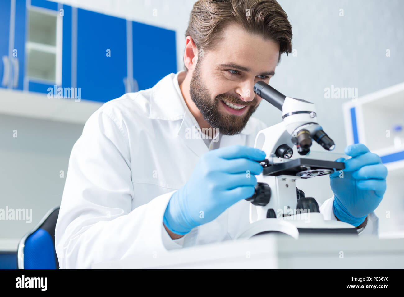 Successful experiment. Cheerful positive smart scientist looking into ...