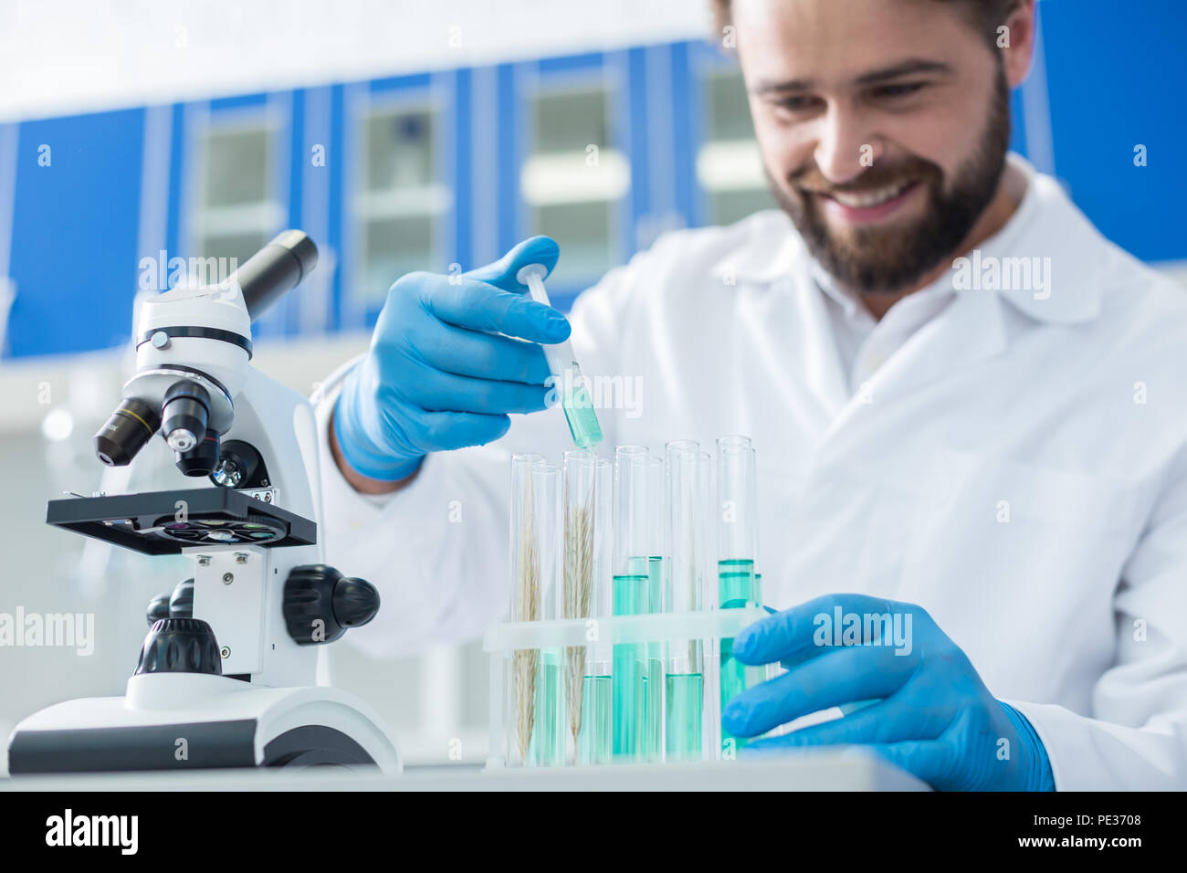 Biological project. Delighted nice smart biologist holding a syringe ...
