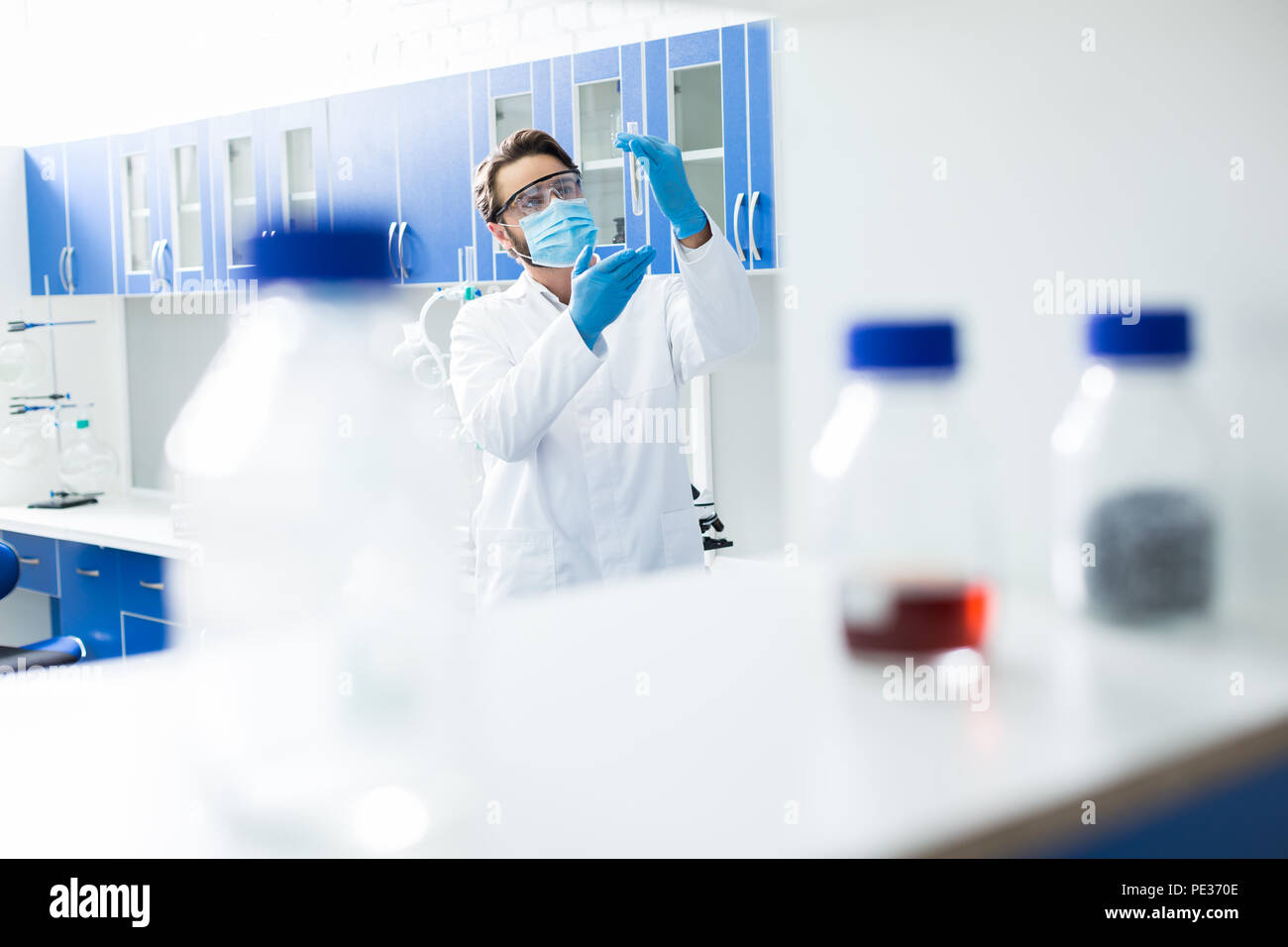 Bio laboratory. Smart nice handsome scientist standing in the lab and ...