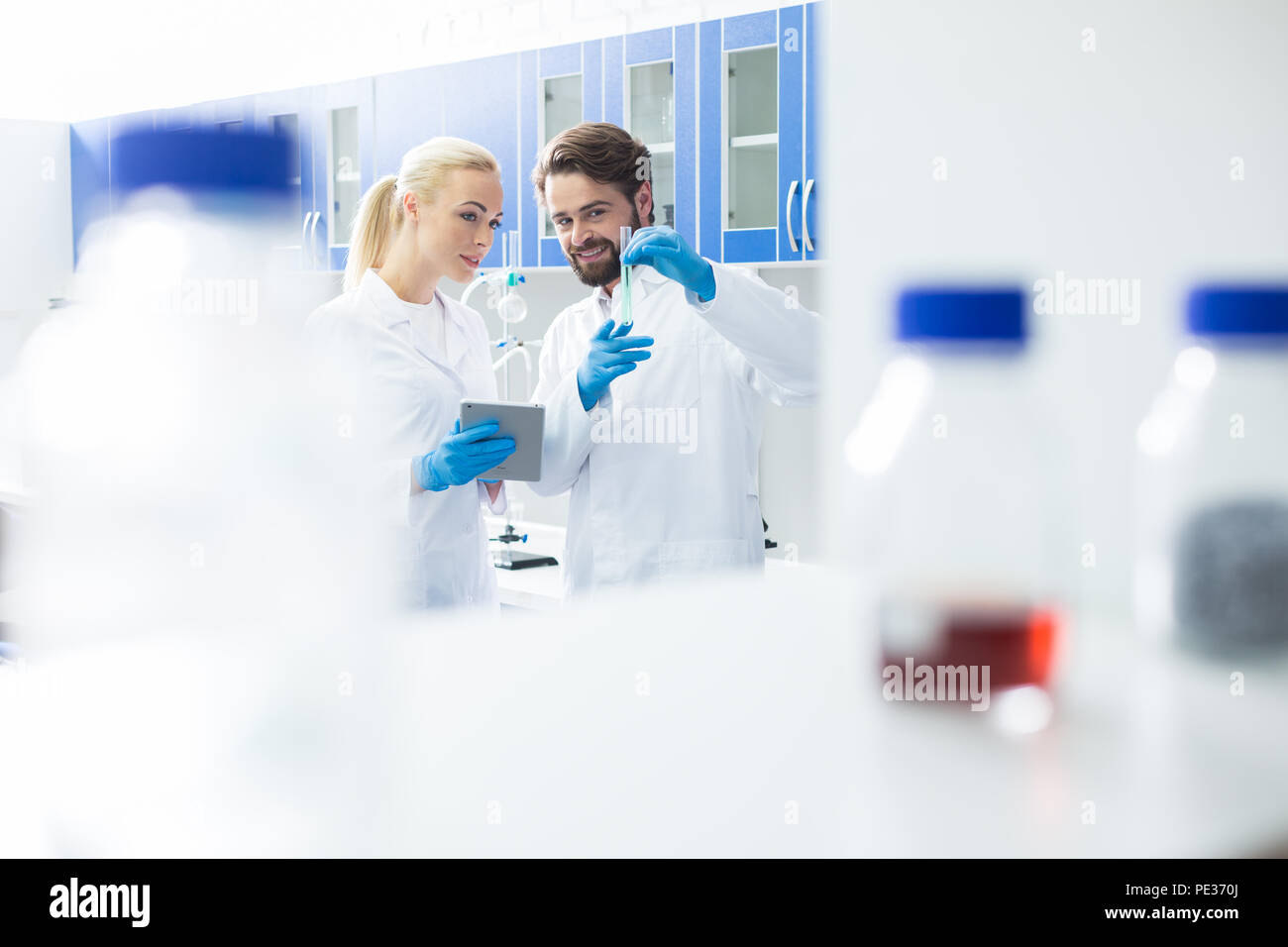 Cooperation and teamwork. Cheerful nice positive scientist standing ...