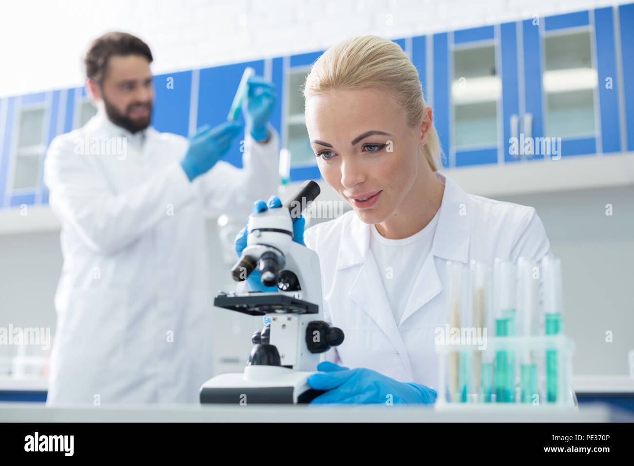 Female scientist. Positive delighted smart woman sitting in front of ...