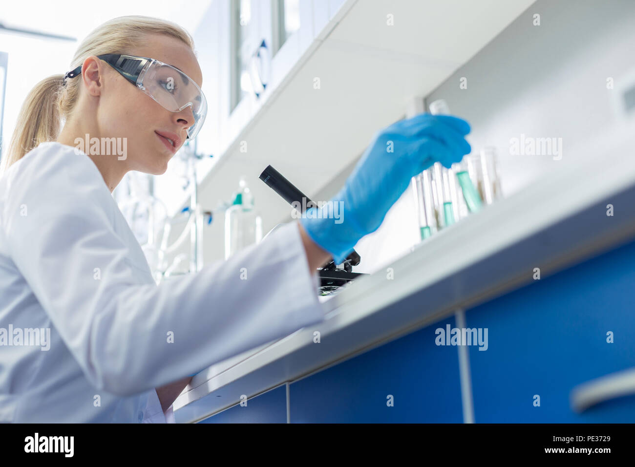 Modern science. Positive intelligent female scientist smiling and ...