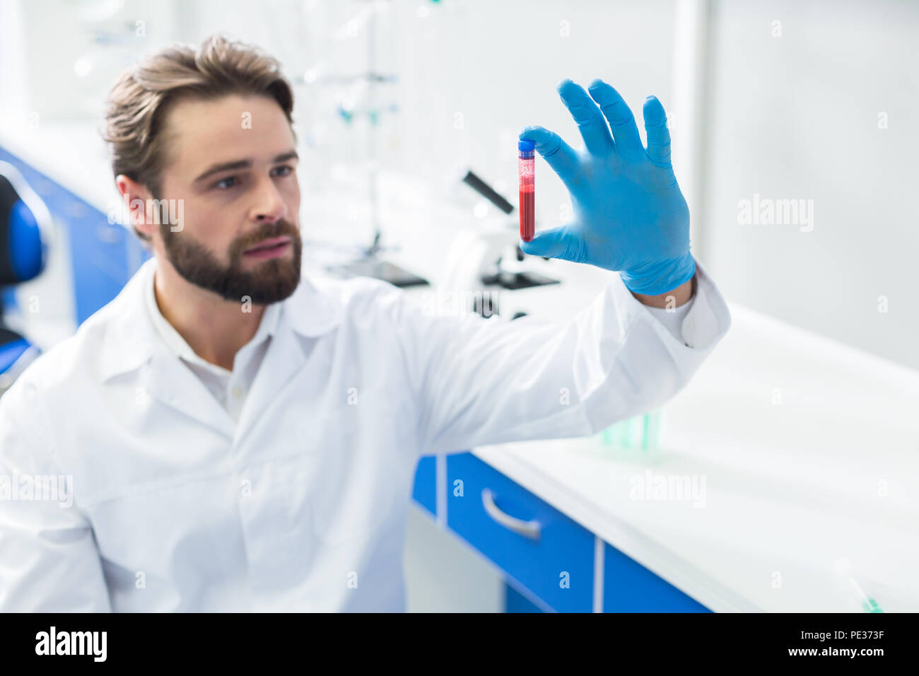 Medical laboratory. Selective focus of blood sample being held by a ...