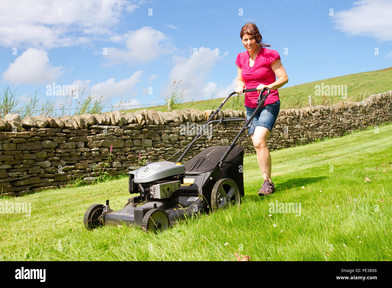 Woman using lawnmower Stock Photo - Alamy