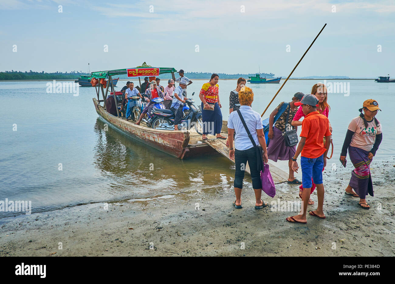 CHAUNG THA, MYANMAR - FEBRUARY 28, 2018: The crowded raft-ferry across ...