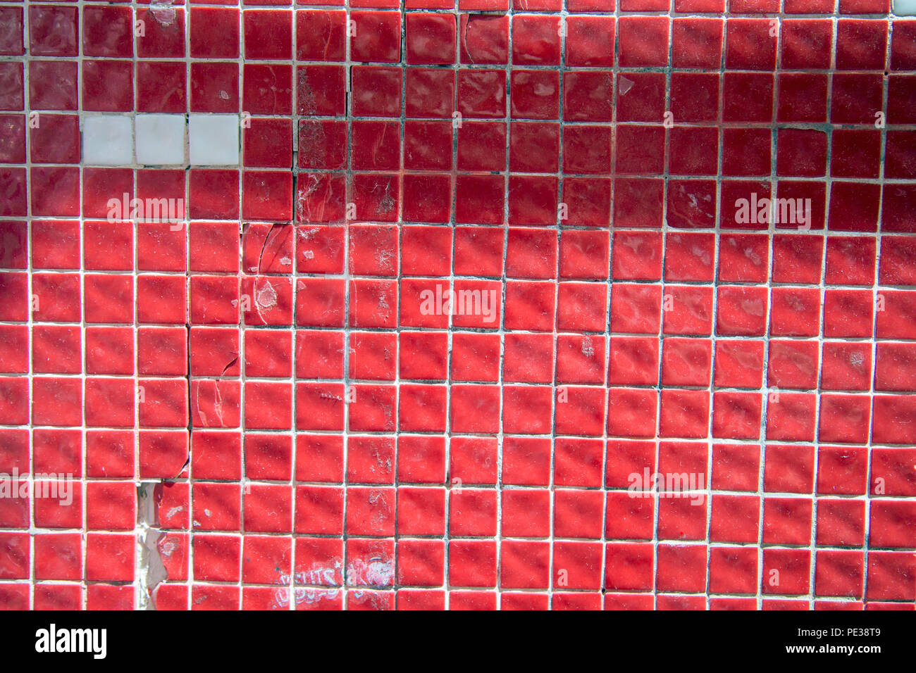 Small red tiles with some distressed areas completely filling the frame ...