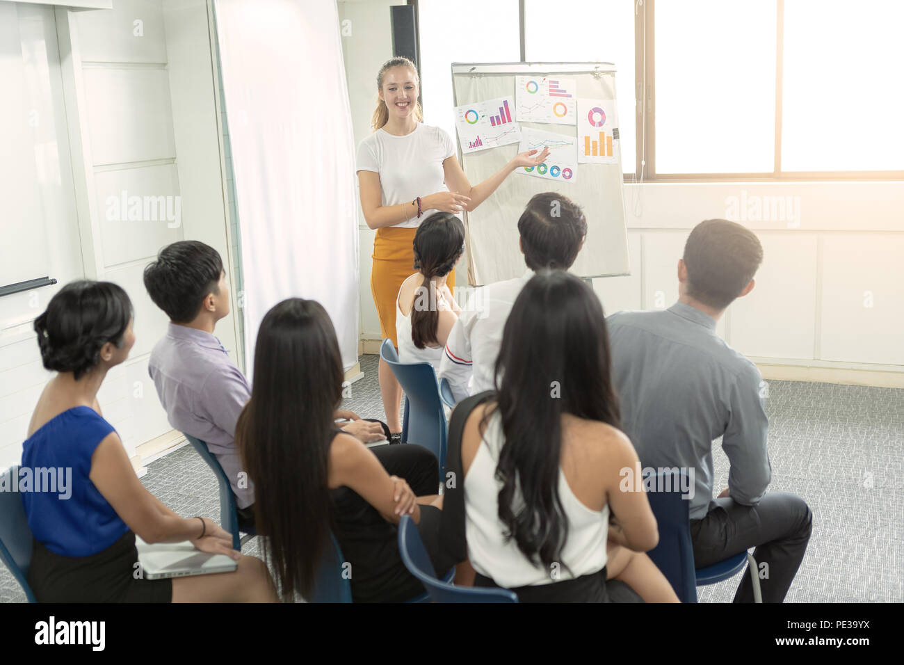 Group of business people sitting on presentation at office in front of ...