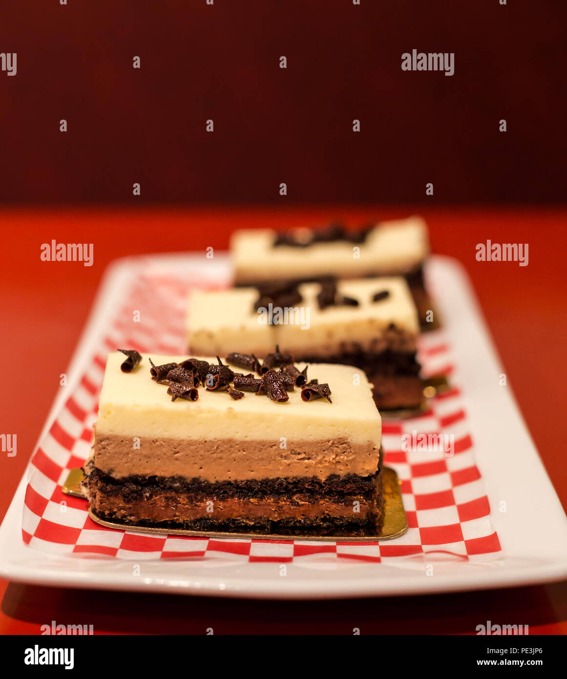 Three layer chocolate mousse cake on a white plate Stock Photo - Alamy