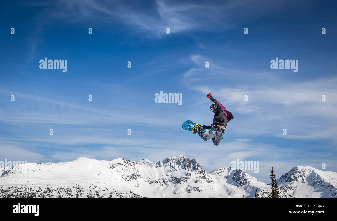 Snowboarder in mid-air grabbing the back of his board Stock Photo - Alamy