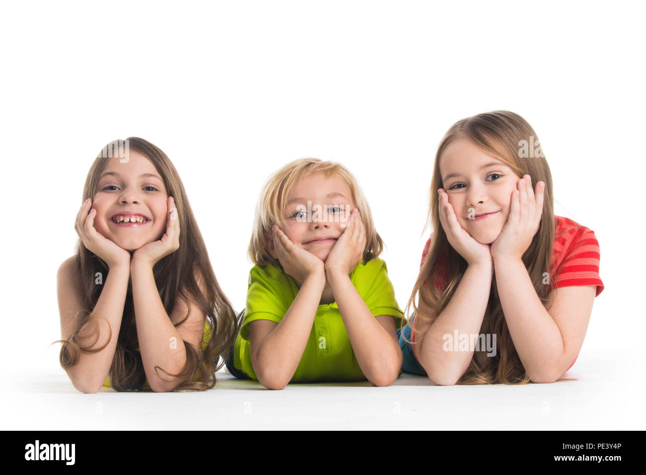Happy smiling three children in colorful clothes laying on floor ...