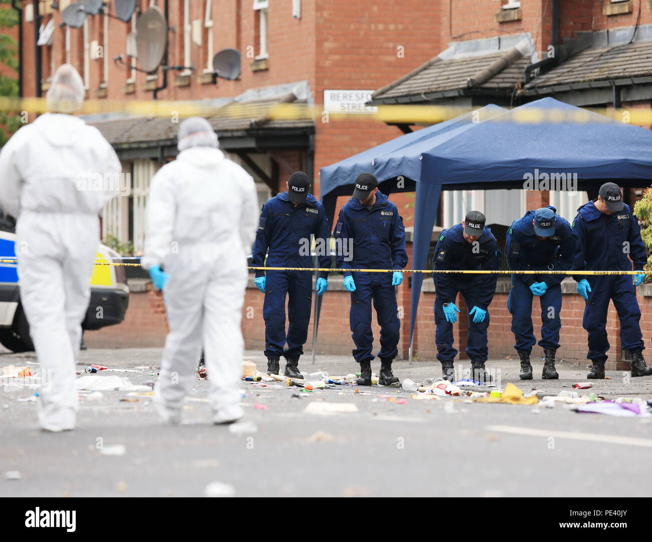 Police from the Tactical Aid Unit carry out a fingertip search in ...