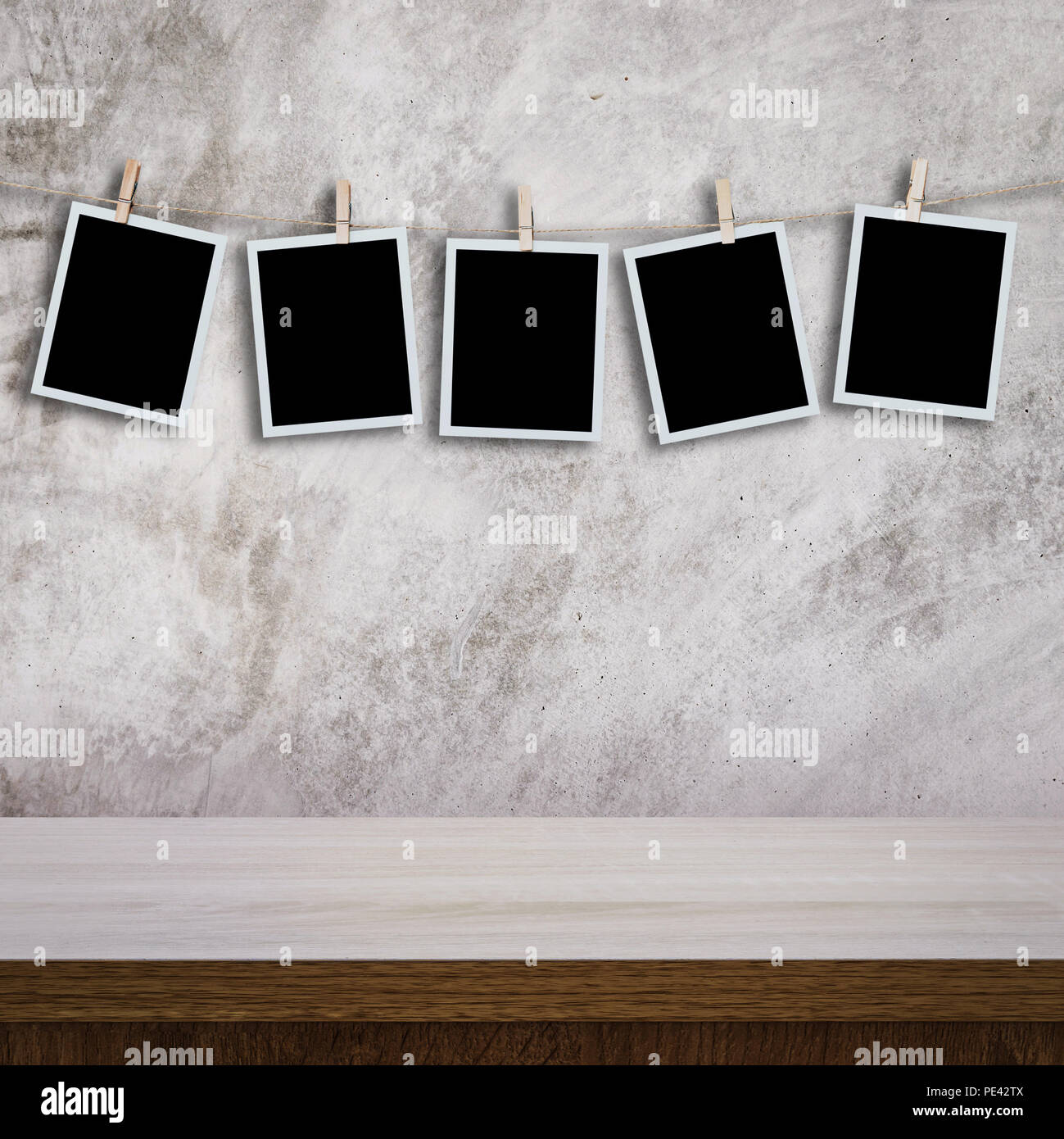 instant photo hanging on wood table and cement wall texture background ...