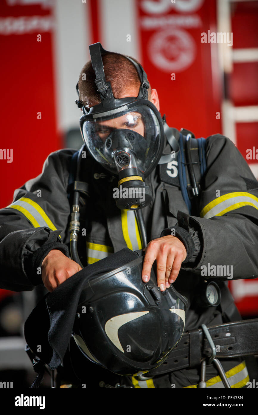 Photo of fireman wearing gas mask near fire engine Stock Photo - Alamy