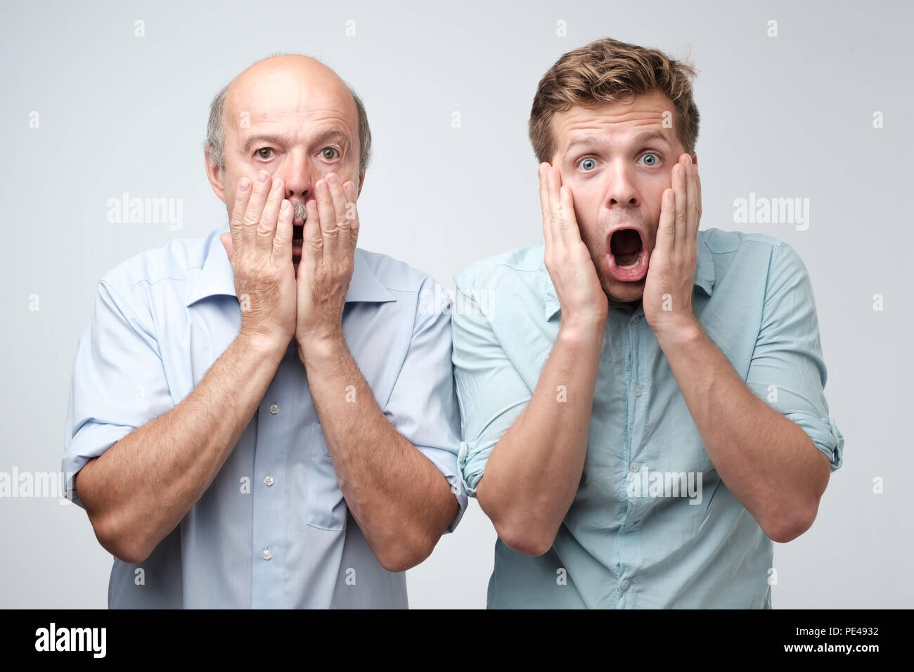 Frightened two men have scared expressions, look nervously, isolated ...