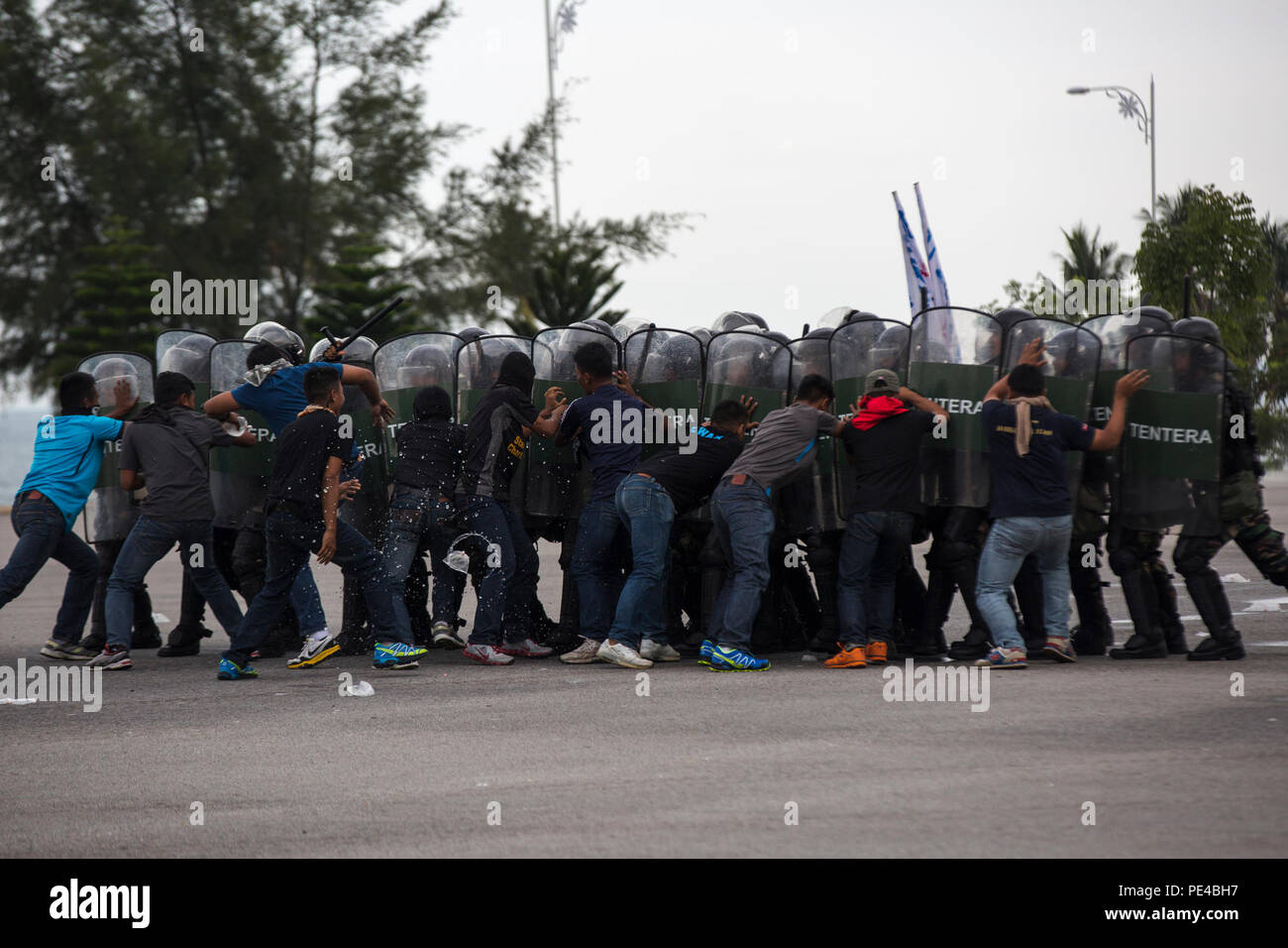 Members of a mock riot mob attack a Malaysian Armed Forces riot control ...