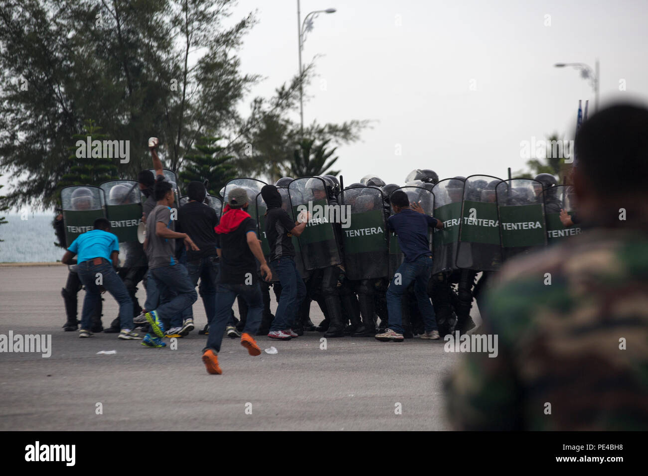 Members of a mock riot mob attack a Malaysian Armed Forces riot control ...