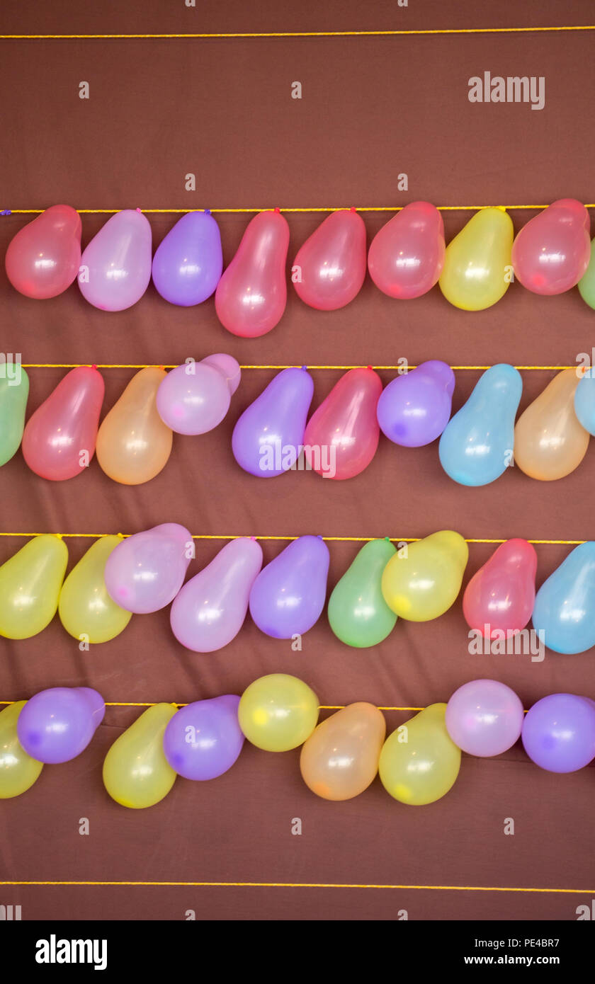Balloon shooting game with balloons tied on a string Stock Photo - Alamy