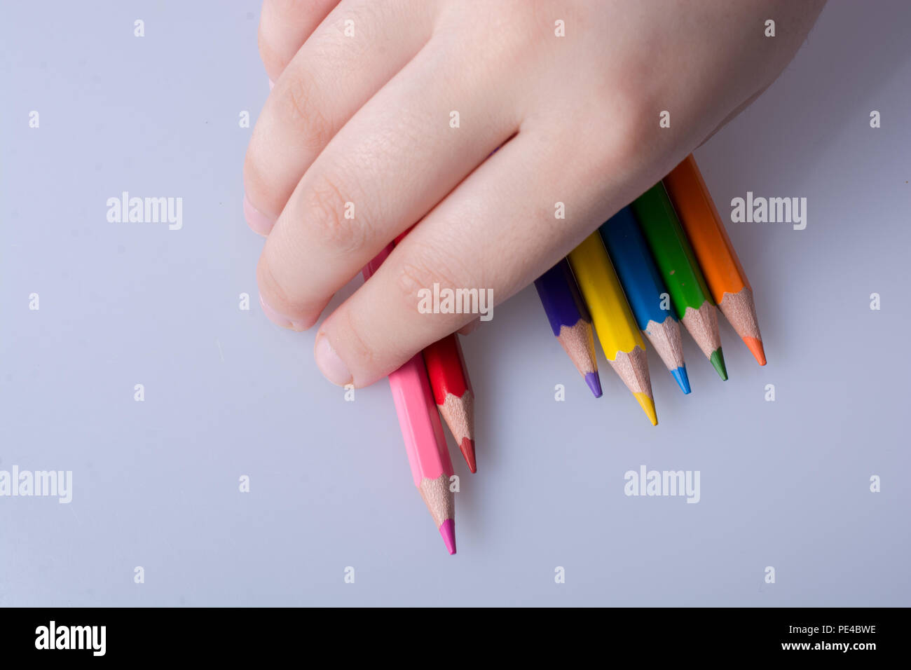Hand holding color Pencils placed on a white background Stock Photo - Alamy