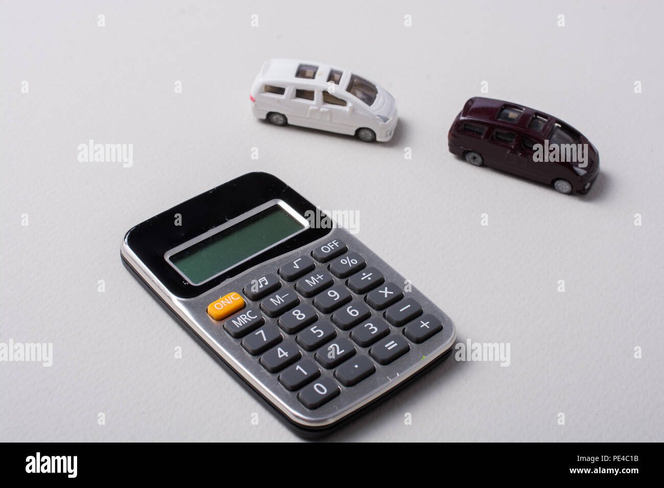 Little size cars beside a calculator on white background Stock Photo ...