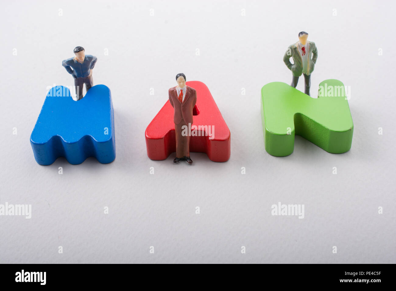 Tiny figurine of men beside colorful wooden letters say MAN Stock Photo ...