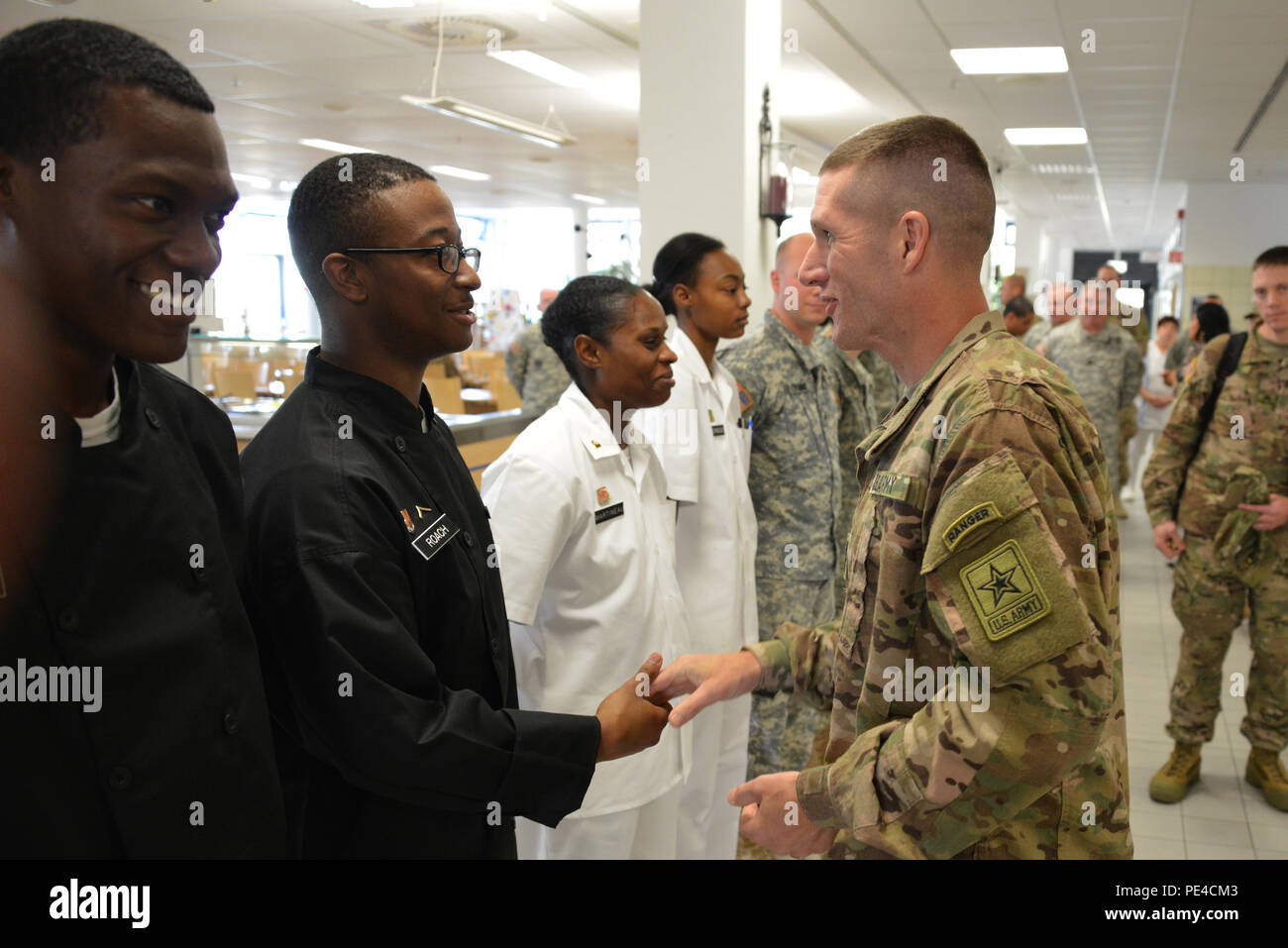Sgt. Maj. of the Army Daniel A. Dailey (right) presents coins to ...