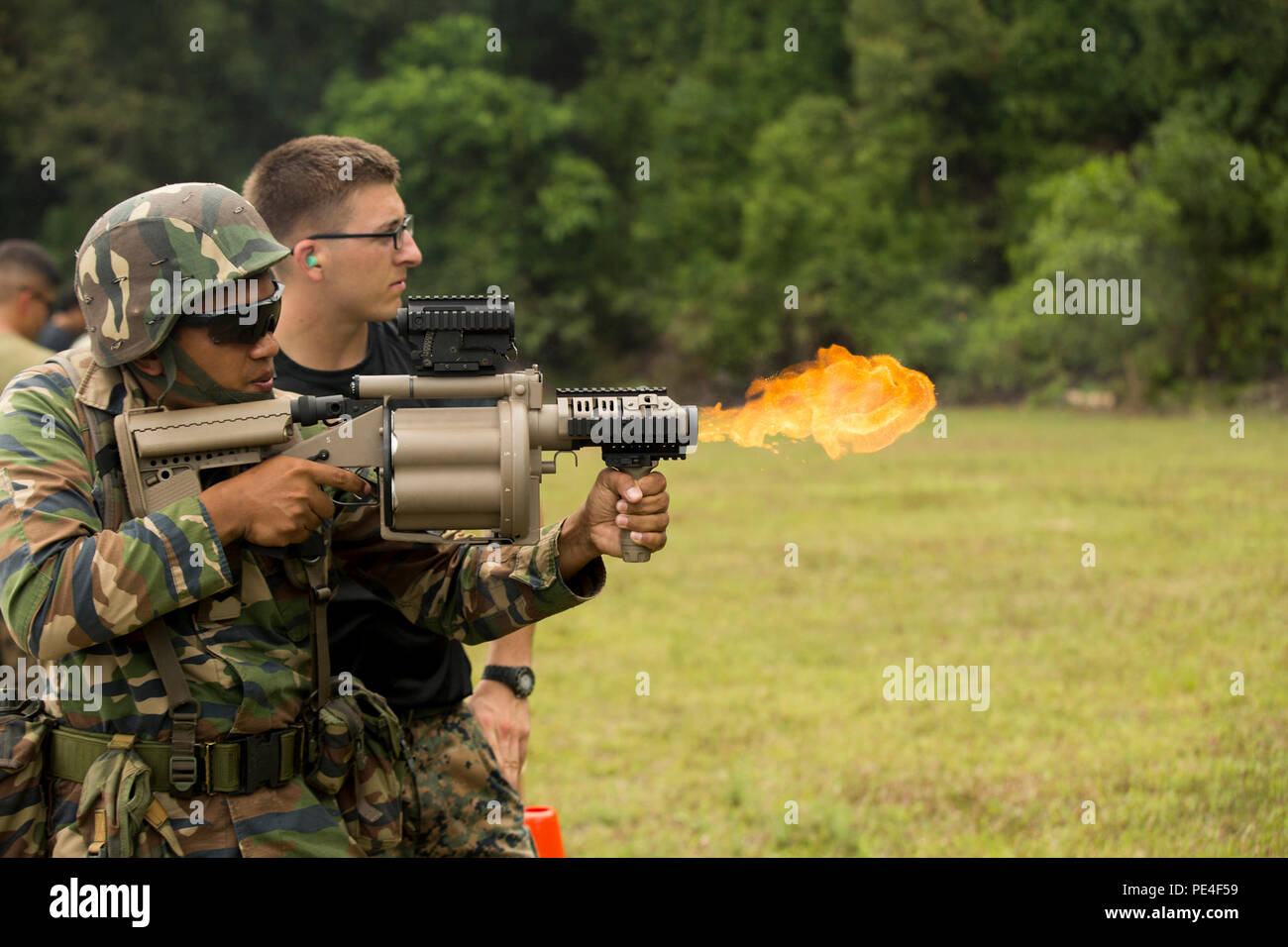 A Malaysian Armed Forces service member fires an M32 Grenade Launcher ...
