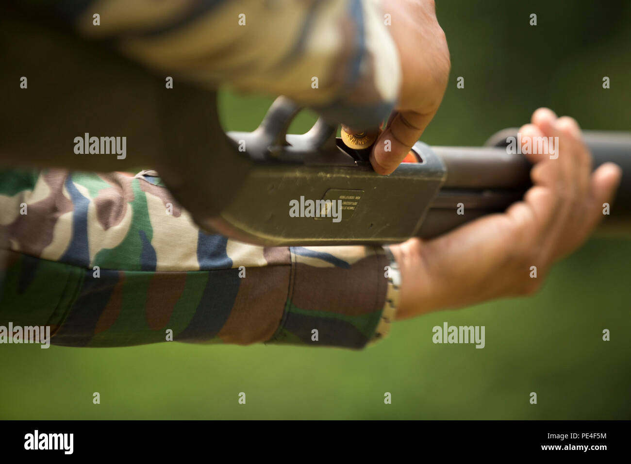 A Malaysian Armed Forces service member reloads an M500A1 Shotgun ...