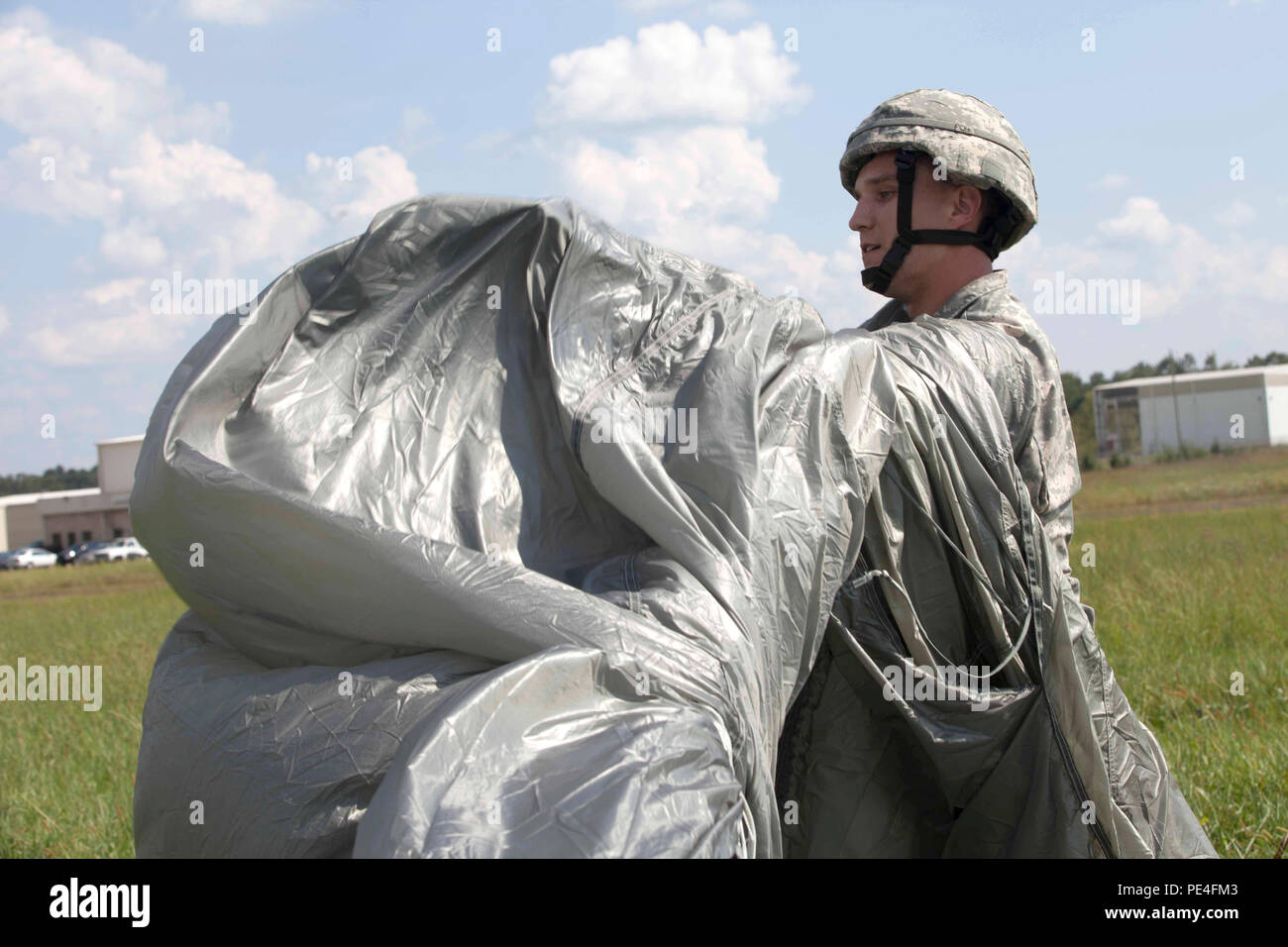 A U.S. Army paratrooper begins to gather his parachute on Steve Osborne ...