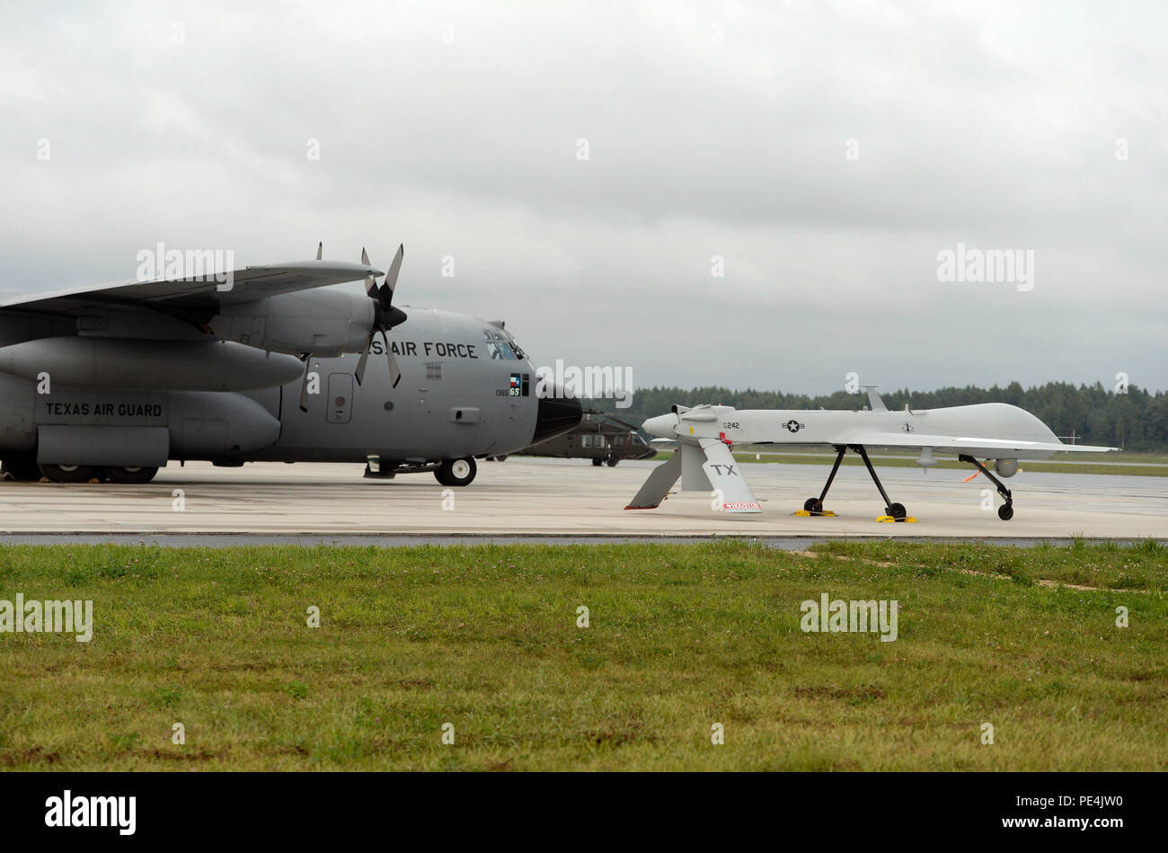 A 136th Airlift Wing C-130 is parked behind a 147th Reconnaissance Wing ...