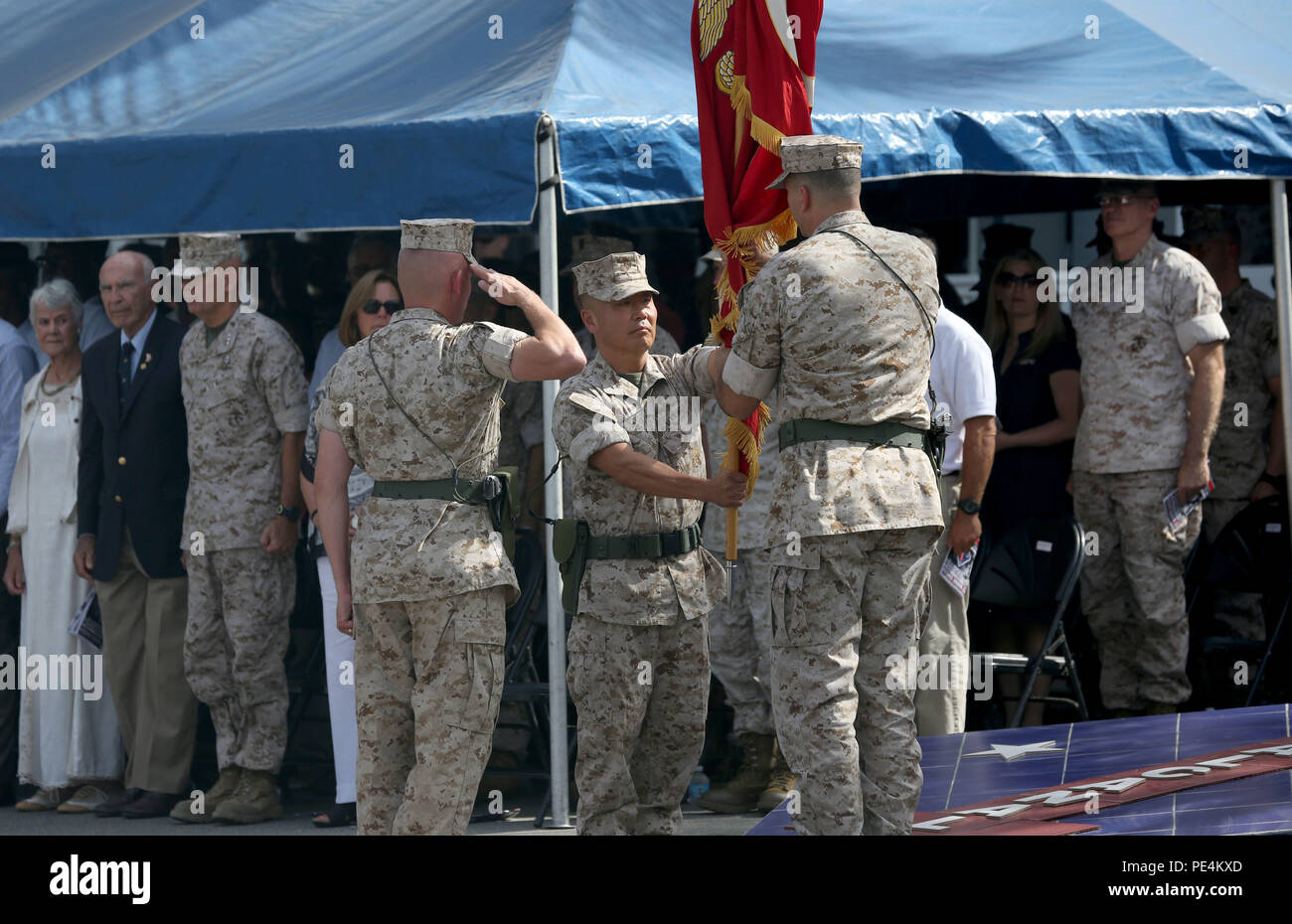 Brig. Gen. Daniel D. Yoo (center), hands the 1st Marine Division colors ...