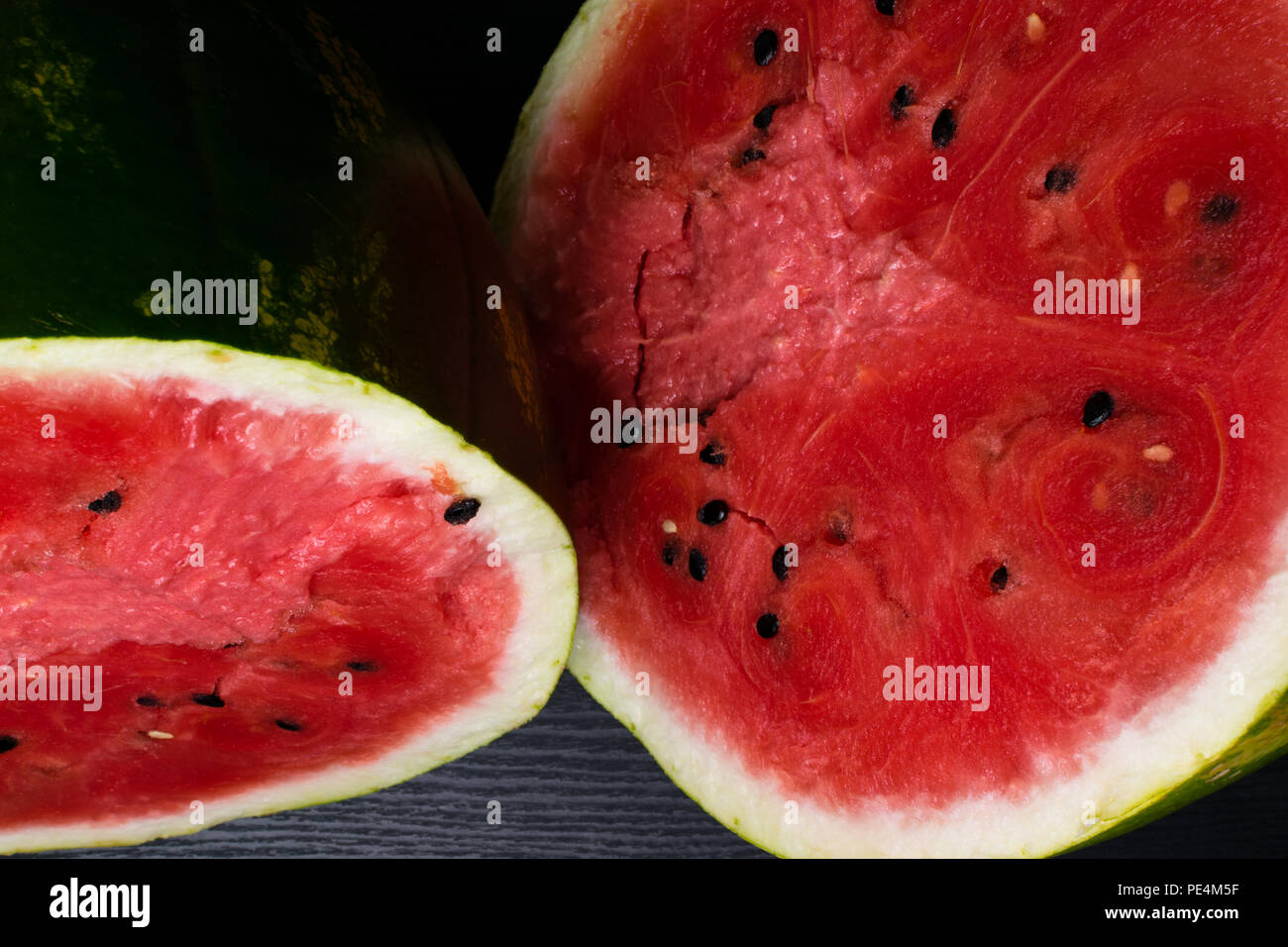 delicious watermelon cut in halves isolated on black background with ...
