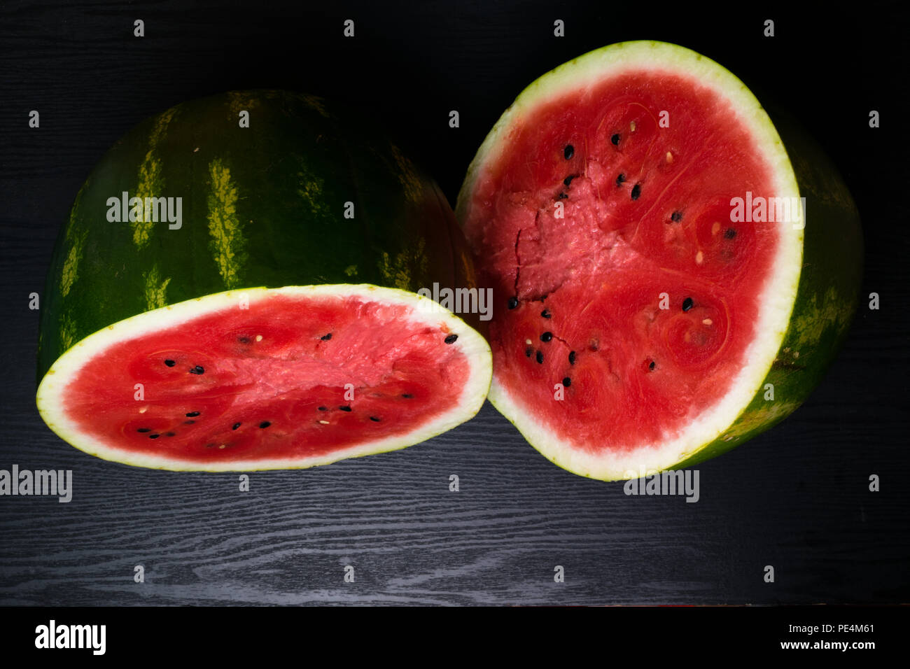 delicious watermelon cut in halves isolated on black background with ...