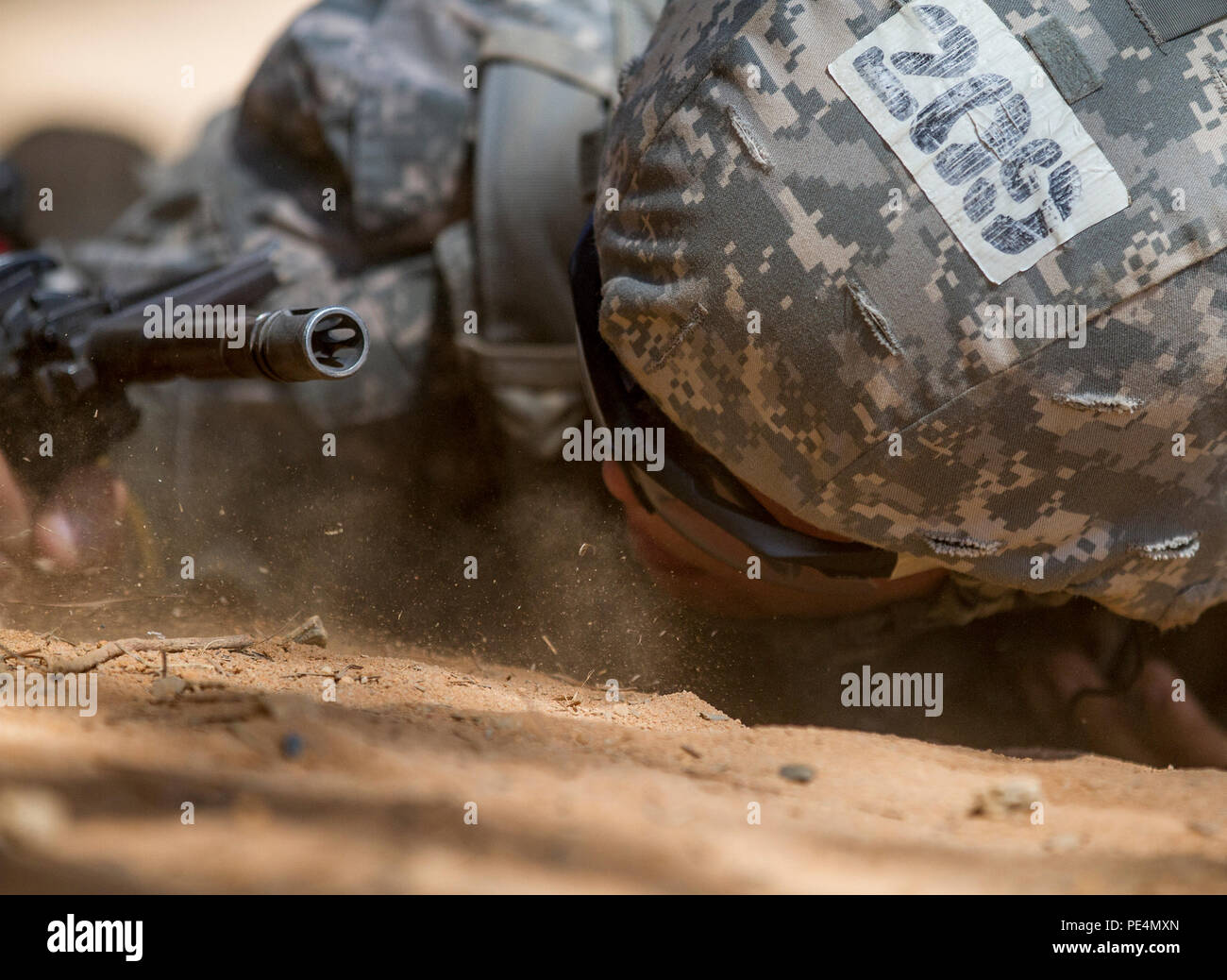A U.S. Army Soldier low crawls through an obstacle on a buddy team live ...