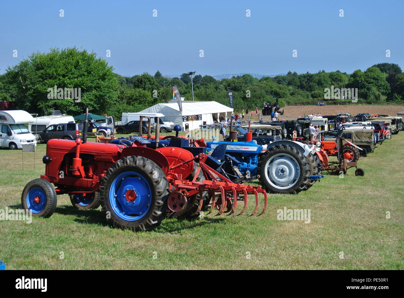 A line of vintage tractors and Land Rovers parked up on display at ...