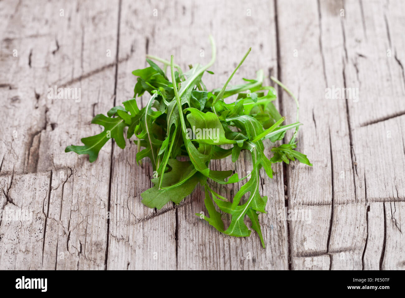 fresh rucola on rustic wooden background Stock Photo - Alamy