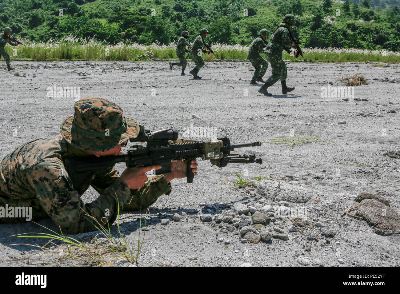 A U.S. Marine sights in on his rifle as Philippine Marines move up ...