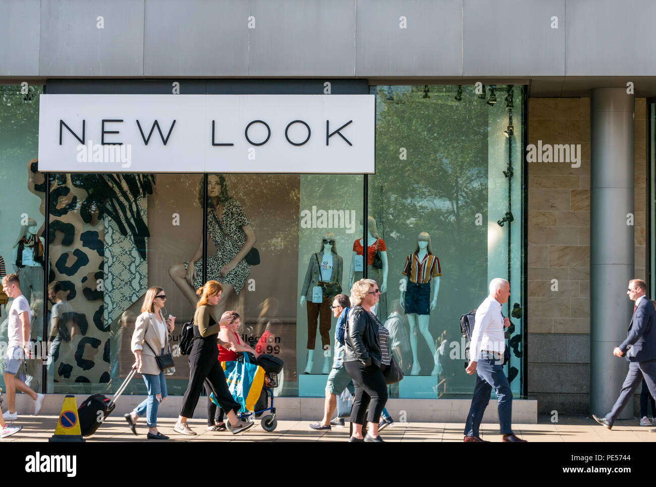 Shoppers walking past frontage of New Look store with mannequins in ...