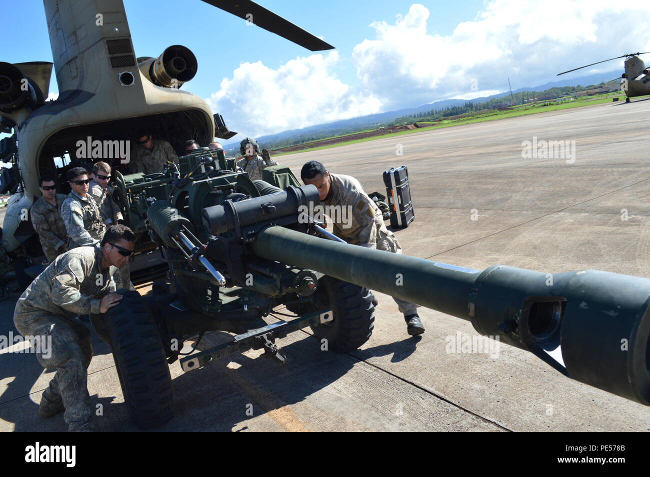 New Zealand and U.S. Soldiers offload an M119A3 105mm howitzer from a CH-47 helicopter at ...