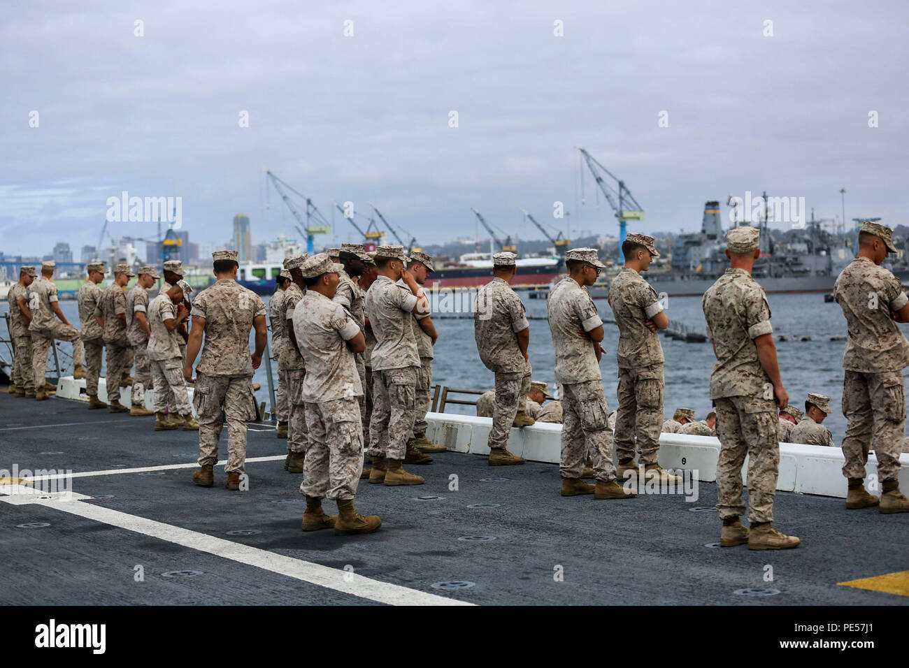 Marines and Sailors with the 13th Marine Expeditionary Unit look on as ...